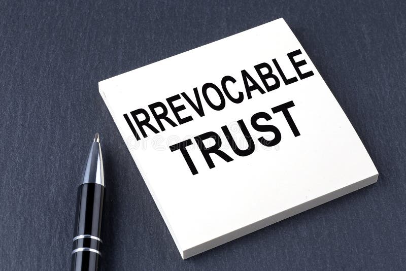 IRREVOCABLE TRUST Text on the Sticker with Pen on the Black Background ...