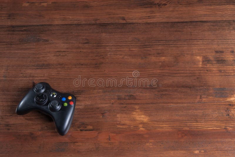 There is a Gaming Controller on the Table by Himself and he is Next To ...