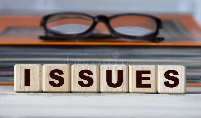 ISSUES - Word on Wooden Cubes on the Background of a Folder with ...