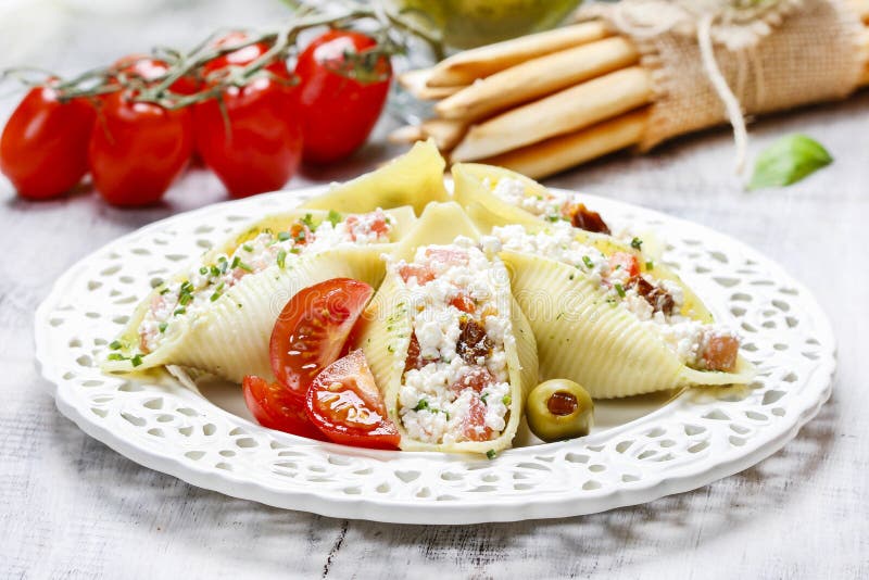 Italian Cuisine: Stuffed Pasta Shells and Stack of Breadsticks. Stock ...
