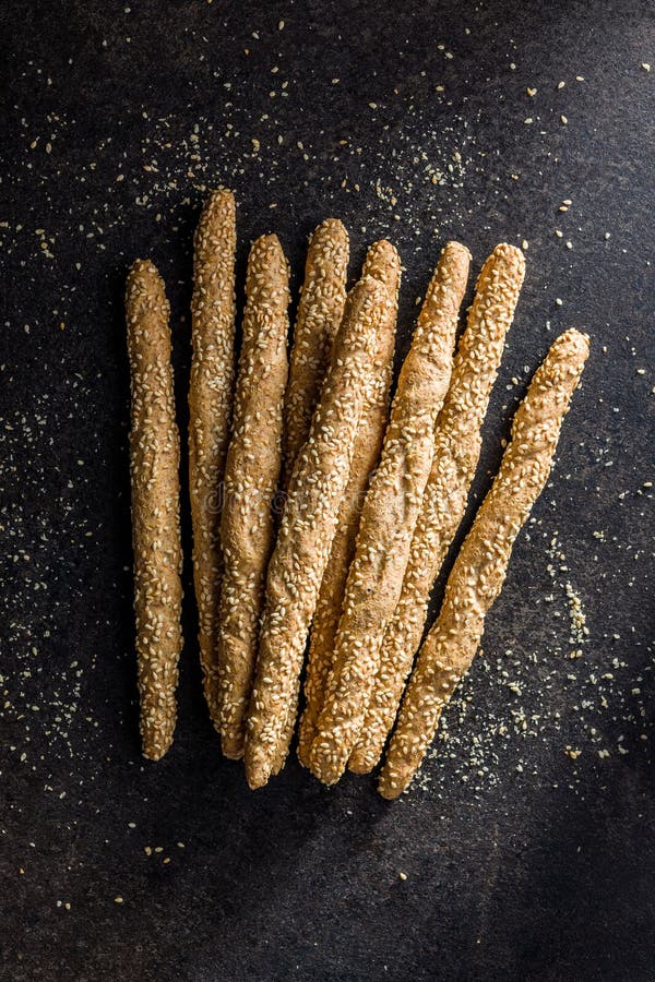 Italian Grissini Bread Sticks with Sesame Seeds on Black Table. Top ...