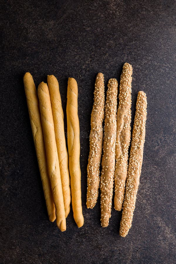 Italian Grissini Bread Sticks with Sesame Seeds on Black Table. Top ...
