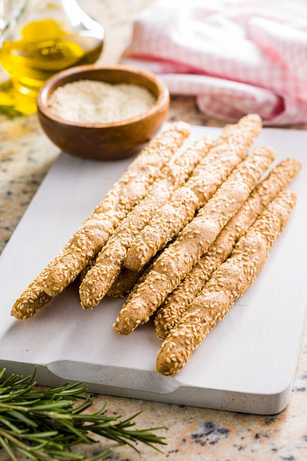 Italian Grissini Bread Sticks with Sesame Seeds on White Cutting Board ...