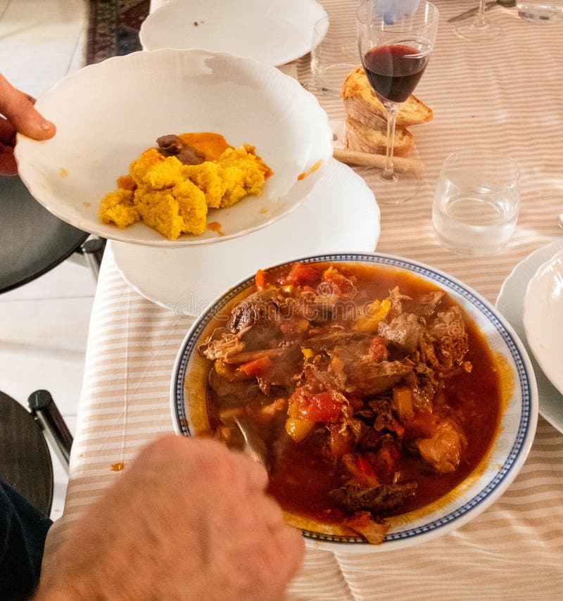 Italian Man Serving Polenta and Rabbit with Tomato Sauce and Wine and ...