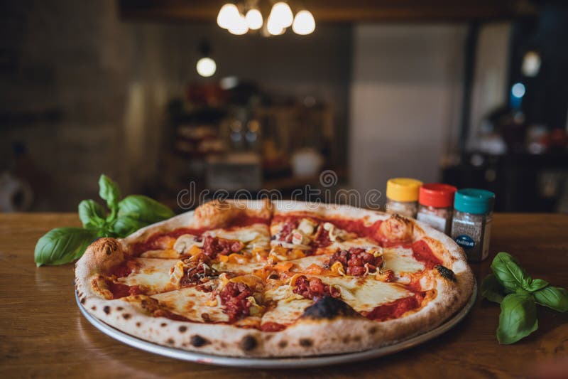 Italian Pizza with Assorted Toppings on a Rustic Kitchen Table Stock ...