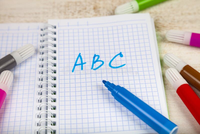 On the Table are Markers, Paper Clips and a Notebook with the ...