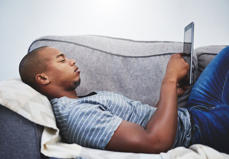 Its Another Laid-back and Lazy Weekend. a Handsome Young Man Using a ...