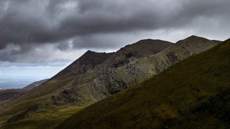 Jagged Mountain Ridges Under a Dramatic, Cloudy Sky, Visible Lower ...