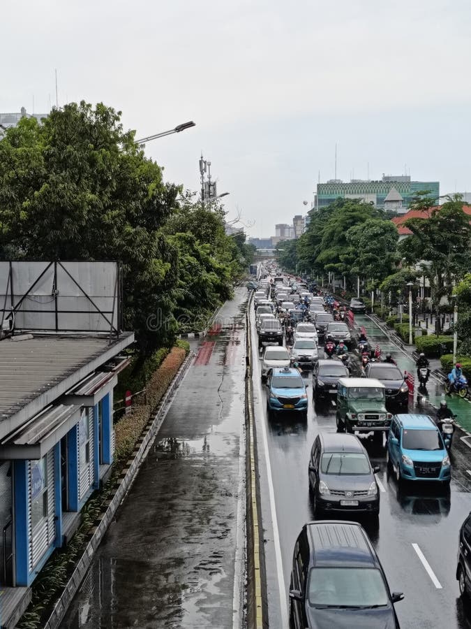 Jakarta road after rain editorial photography. Image of people - 277233267