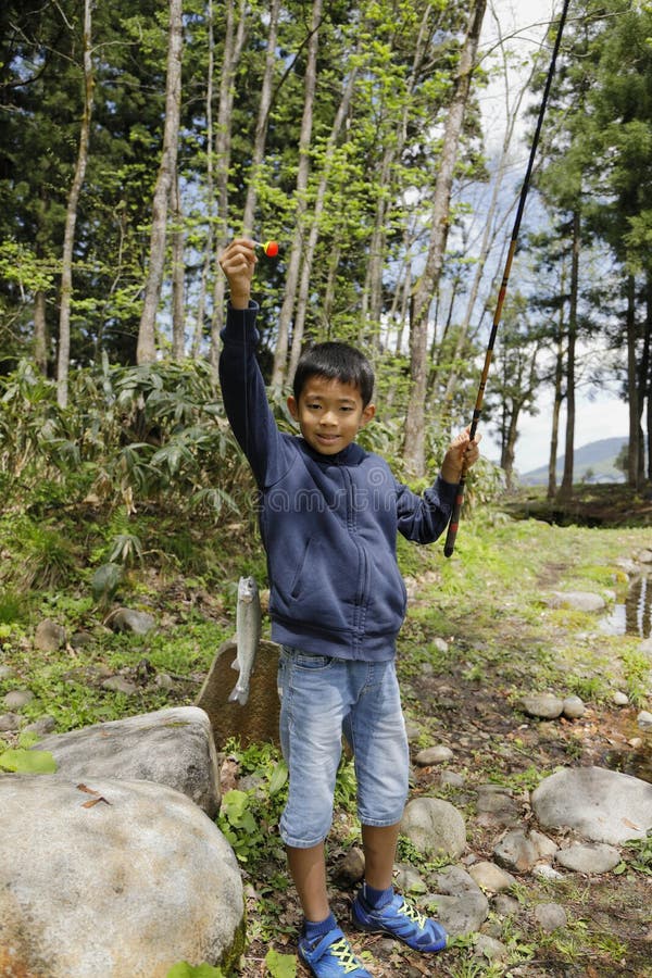 Japanese boy catching fish stock image. Image of person - 147659919