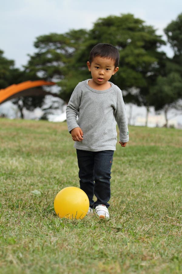 Japanese Boy Kicking a Yellow Ball Stock Image - Image of smiling ...