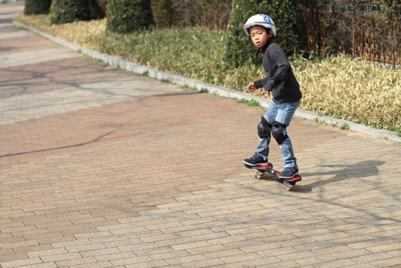 Japanese Boy Riding on a Casterboard Stock Photo - Image of grader ...