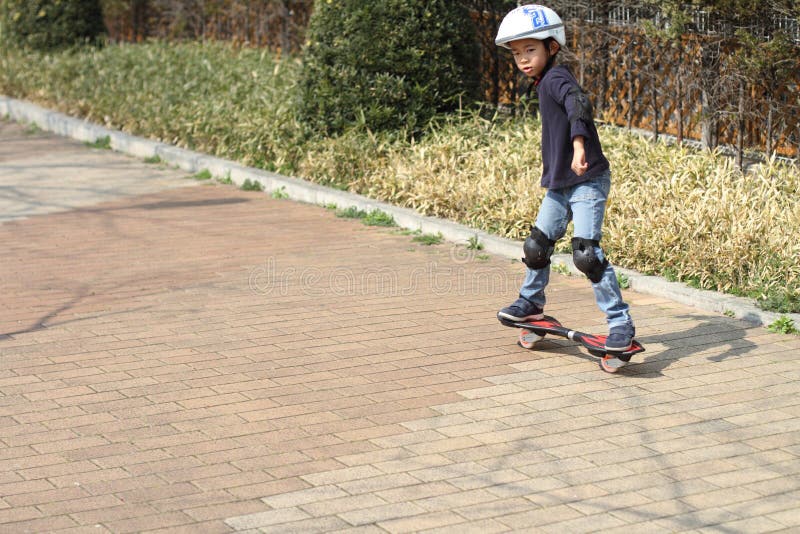 Japanese Boy Riding on a Casterboard Stock Image - Image of ride, clear ...