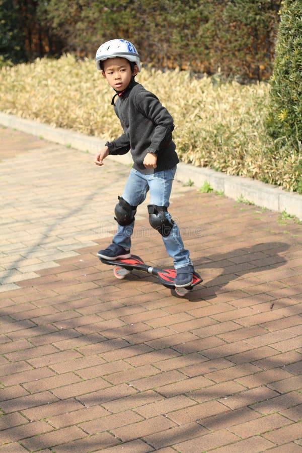 Japanese Boy Riding on a Casterboard Stock Photo - Image of smiling ...
