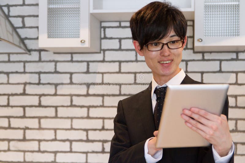 Japanese Young Business Man Talking, Watching Data with Tablet Device ...