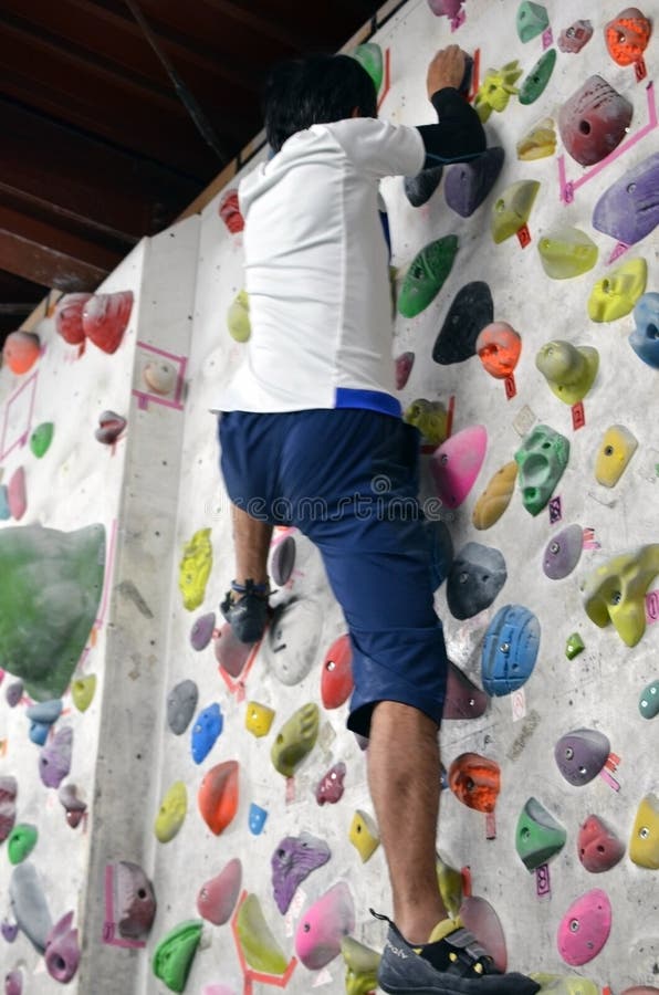 A Japanese Man Climbing a Rock Wall Indoor. Stock Photo - Image of ...