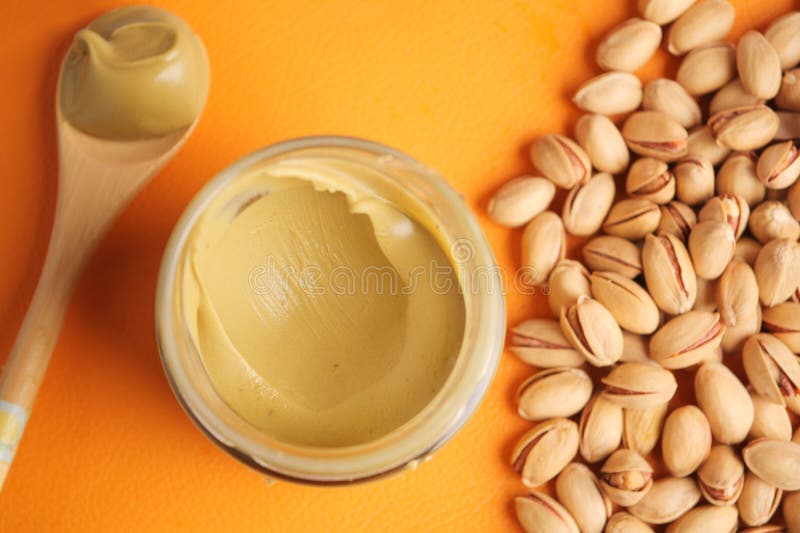 Pistachio Paste in a Jar with Nuts on Orange Background Stock Photo ...