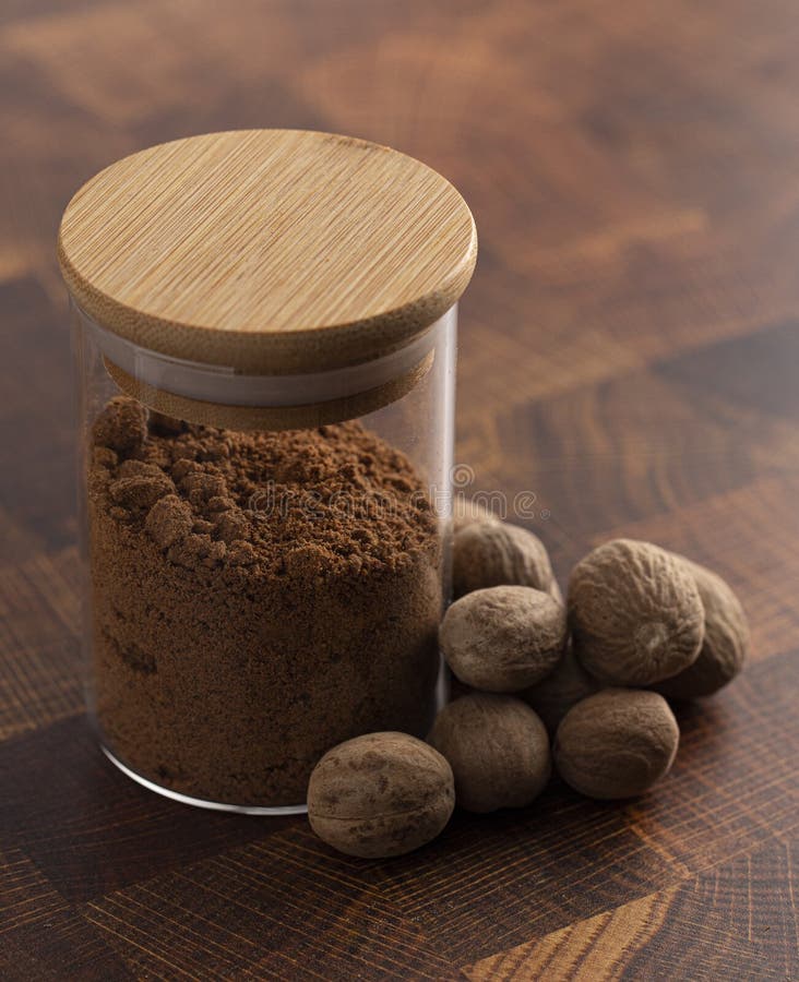 Jar of Ground Nutmeg and Whole Nutmeg on Wooden Butcher Block Stock ...