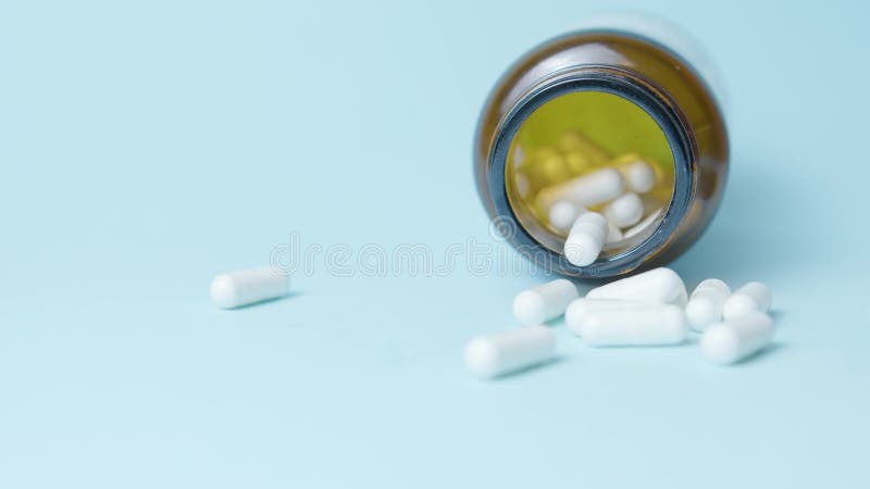 A Jar with White Capsules Medication or Supplements Isolated on Light ...