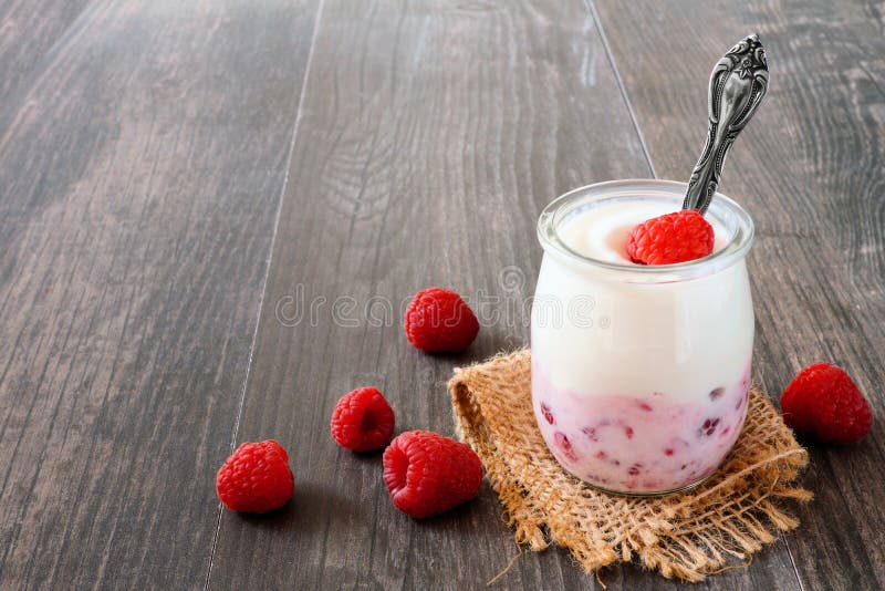 Yogurt with Raspberries in a Jar Against a Wood Background Stock Image ...