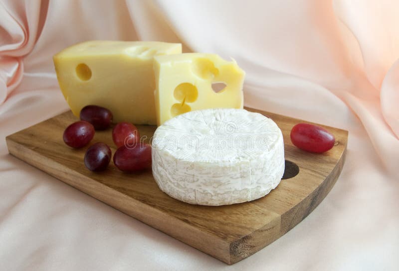 Jarlsberg Cheese with Camembert Cheese and Grapes Stock Photo - Image ...