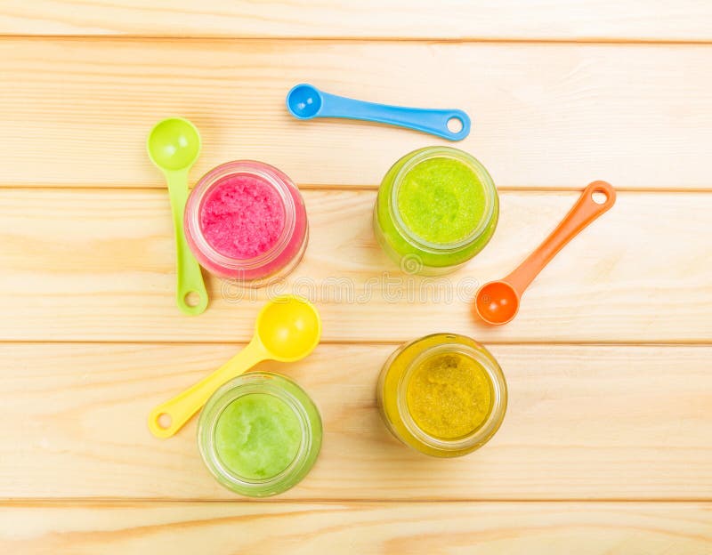 Jars of Different Baby Puree and Color Dimensional Spoon on Light Wood ...