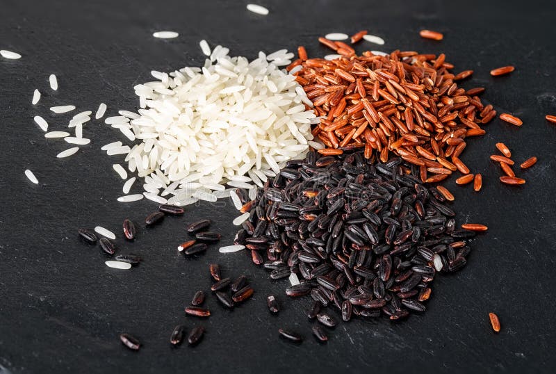 Jasmine Rice, Red Rice, Black Rice on Black Stone Background Stock ...