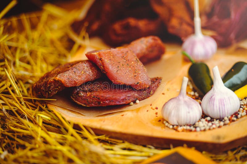 Jerky with Garlic and Pepper Composition on Straw and Wood, Rustic ...