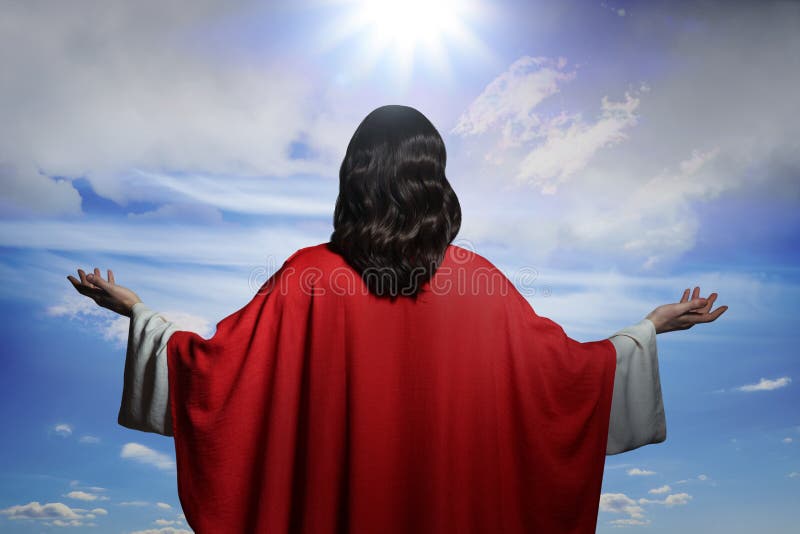 Jesus Christ With Outstretched Arms Against Blue Sky Back View Stock