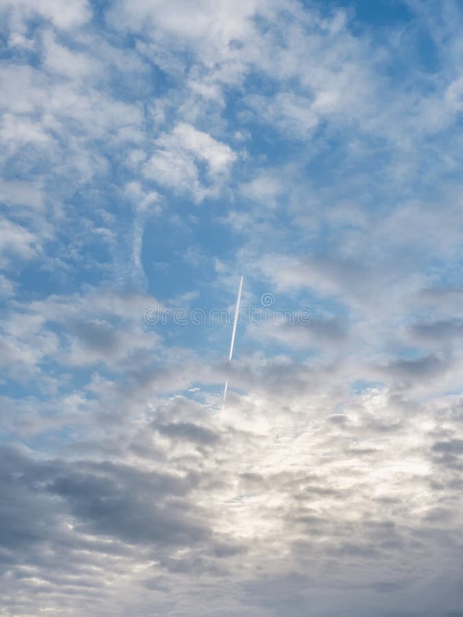 Jet Military Plane Flies through Clouds in a Blue Sky. Vertical View ...