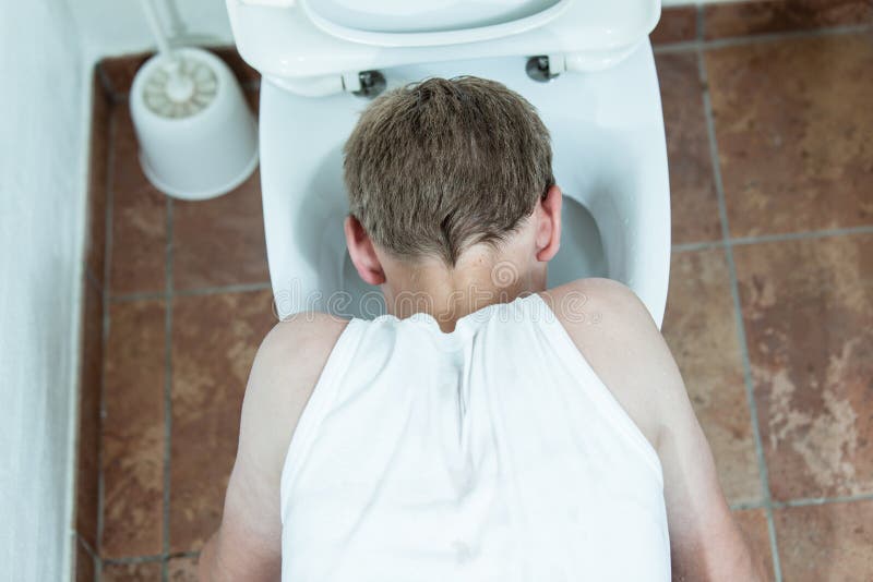 Jeune Homme Vomissant Dans La Cuvette Des Toilettes Photo Stock Image