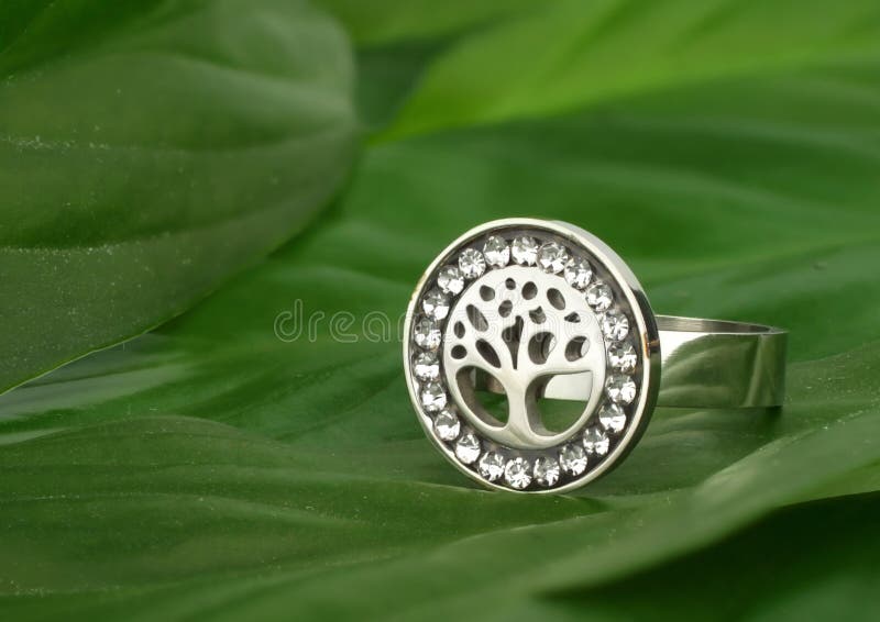 Jewelry Ring with Diamonds, Shape of Tree, on Green Leafs As Background ...