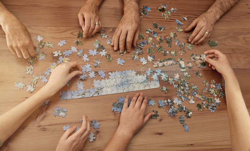 Jigsaw Solutions. Shot of a Group of People Building a Puzzle Together ...