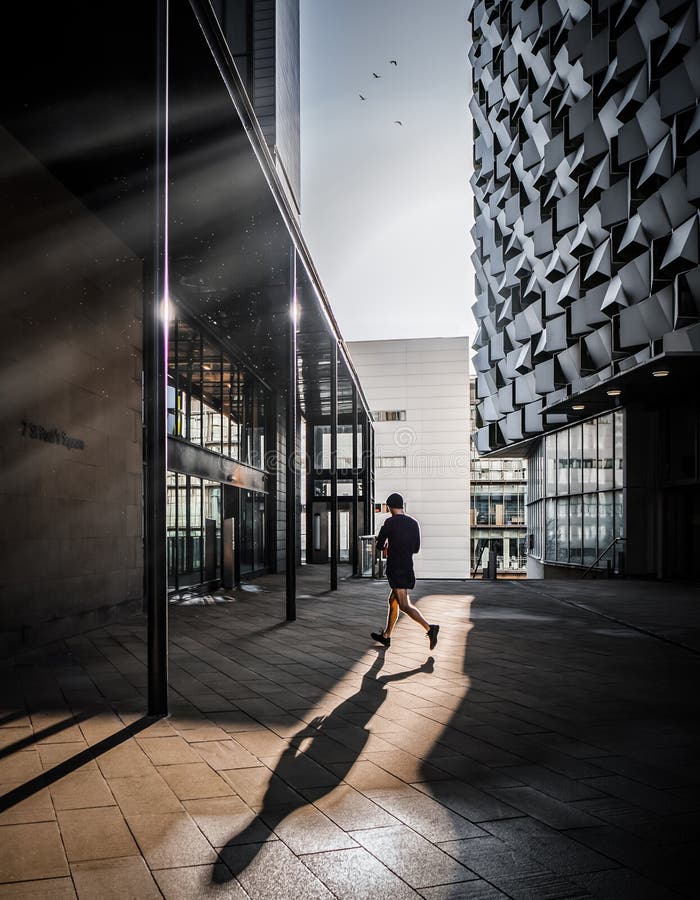 Jogger Running for Exercise through Modern City Buildings As Sun Rises ...