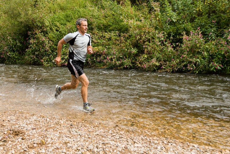 Jogger Running through a Streambed Stock Photo - Image of athlete ...