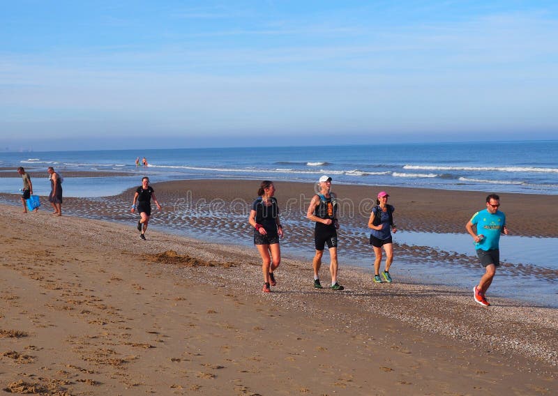 Joggers Running on the Beach at Low Tide Editorial Image - Image of ...