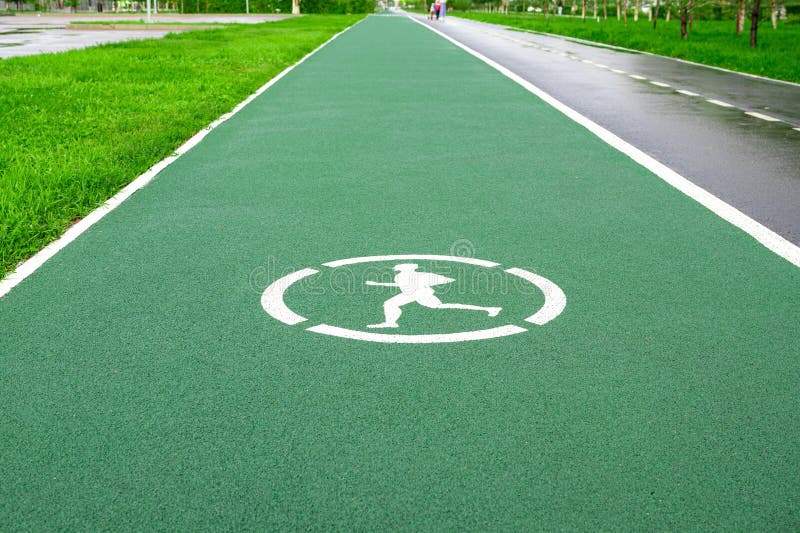 Jogging Path with White Runner Symbol Painted on Green Pavement ...