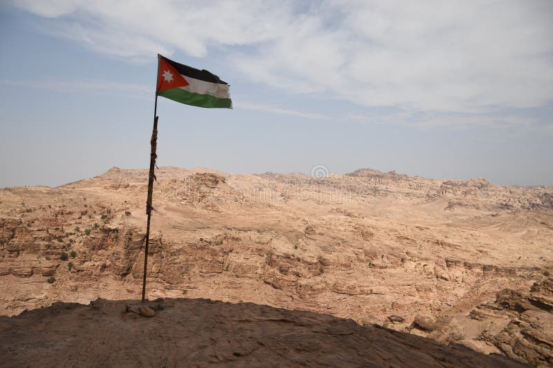 The Flag of Jordan Flies on the Top of a Cliff in Jordan Stock Photo ...