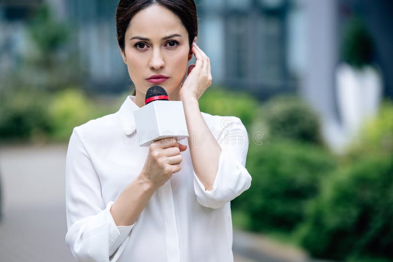 Journalist in Formal Wear Holding Microphone and Looking at Camera ...