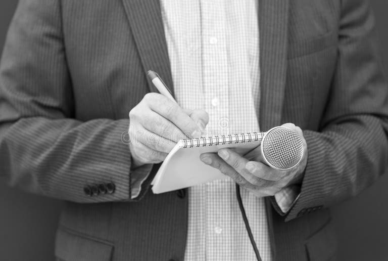 Journalist or Reporter in a Suit Taking Notes on a Notepad while ...