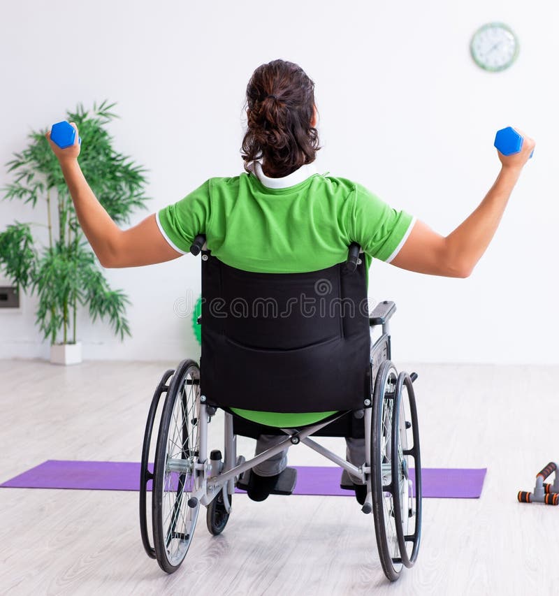 Joven En Silla De Ruedas Haciendo Ejercicios En Casa Foto de archivo ...
