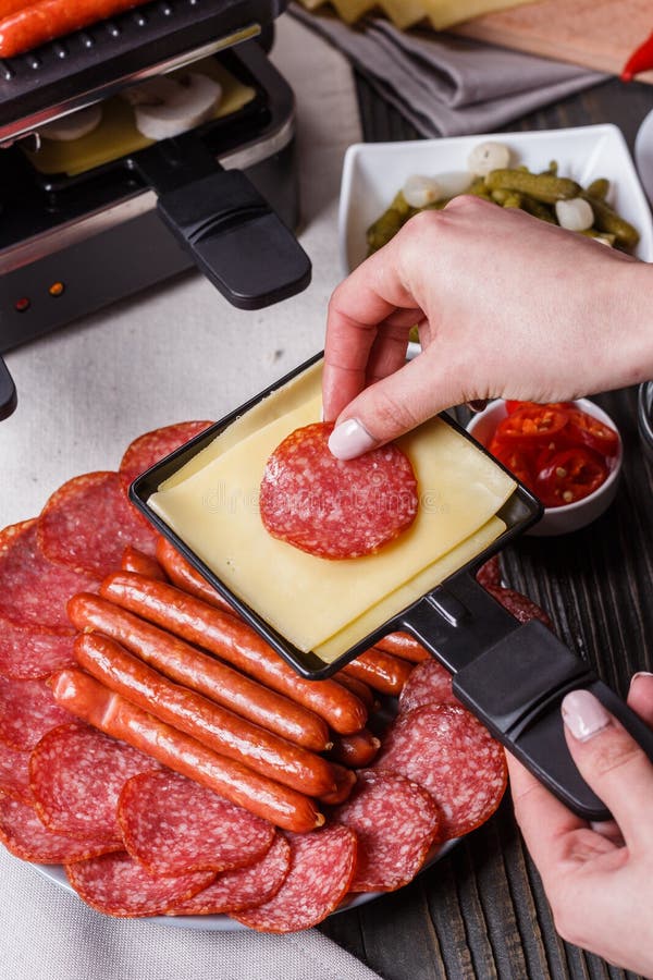 Joven Preparando Una Raclette Tradicional De Queso Suizo Foto de ...