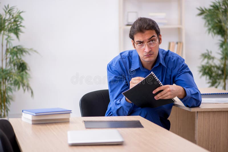 Joven Profesor Revisando Notas En El Aula Imagen de archivo - Imagen de ...