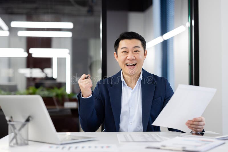 Joyful Eastern Man Making Winner Gesture while Holding Paper Document ...