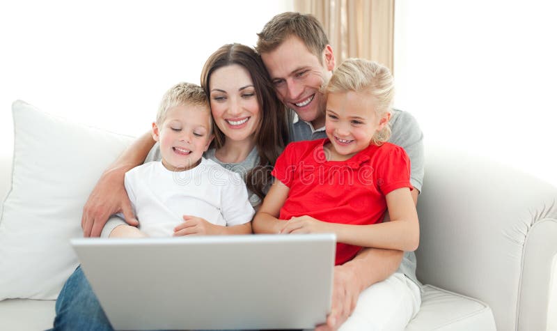Joyful Family Using a Computer Sitting on Sofa Stock Image - Image of ...