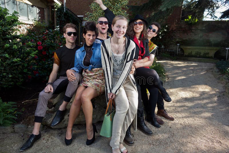 Joyful Friends on Rock in Park Stock Photo - Image of happy, carefree ...