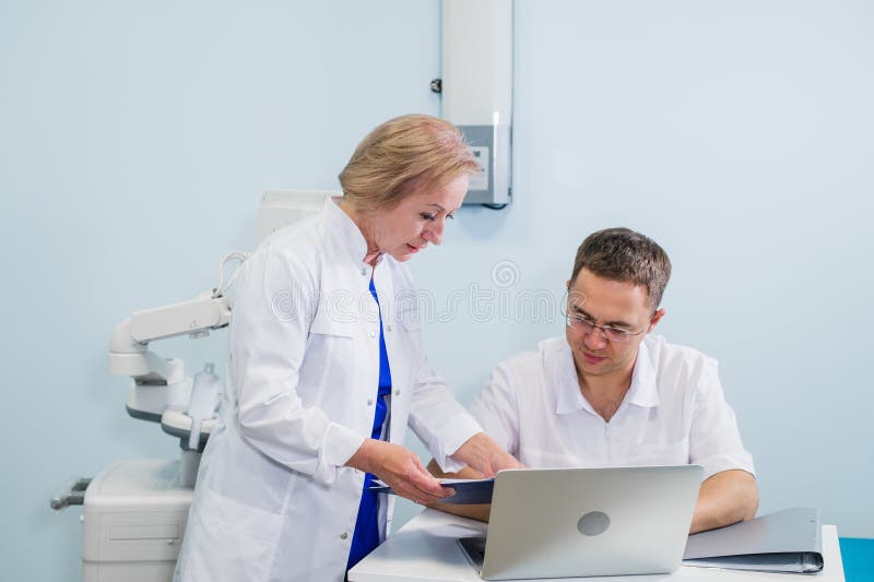 Joyful General Practitioners Discussing Their Work at Hospital Office ...