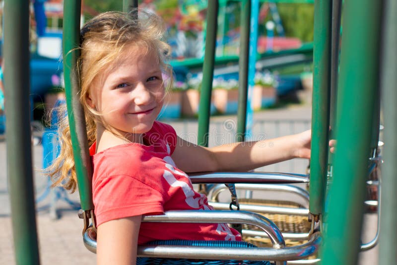 Joyful Girl Rides on a Carousel and Looks at the Camera. Stock Image ...
