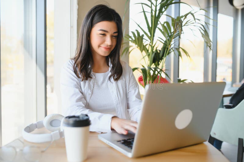 Joyful Girl Student Studying Online at Cafe, Using Laptop and Earphones ...