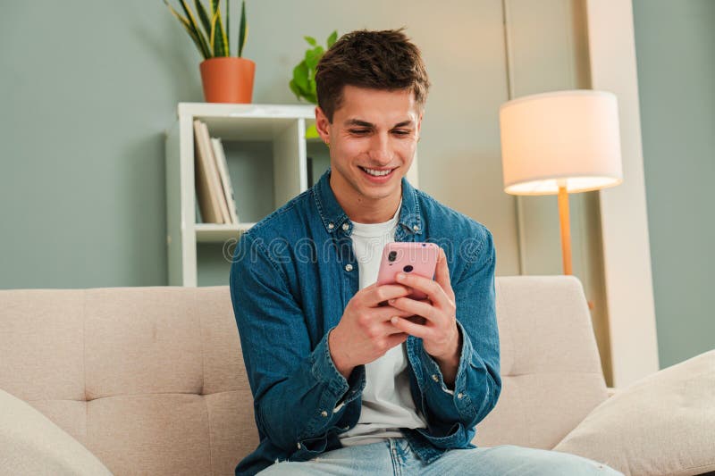 Joyful Guy Browsing with His Cellphone while Relaxing on a Comfy Sofa ...
